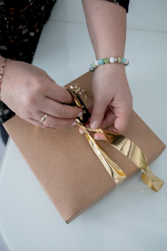 A Woman Wraps a Gift . the Process of Packaging an Environmentally Friendly Gift.Focus on the ...