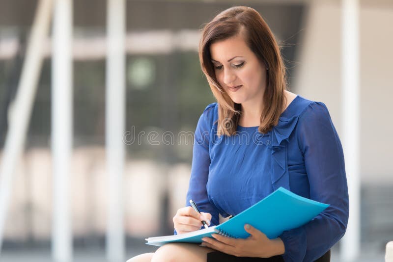 Woman Writing on in a Blue Book Stock Photo - Image of adult, peaceful ...