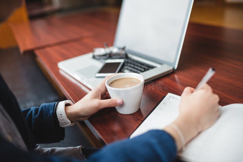 Woman Writing in Book while Having Tea Stock Photo - Image of noting ...