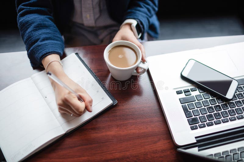 Woman Writing in Book while Having Tea Stock Photo - Image of computer ...