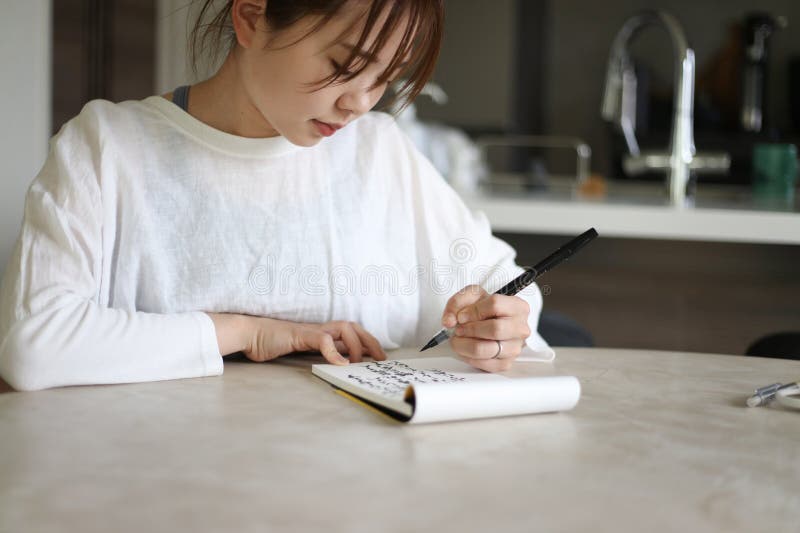 A Woman Writing with a Brush Pen Stock Image - Image of table ...