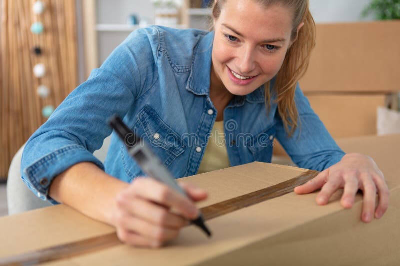 Woman Writing on Cardboard Box Stock Image - Image of holding, contents ...