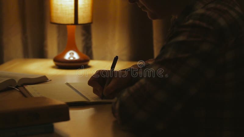 A Woman Writing into Notebook , Sitting by a Lamp. Closeup Stock ...