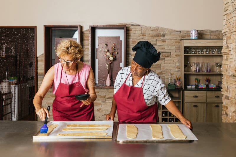 Women Brushing and Preparing Dough for Baking in Cooking Class Stock ...