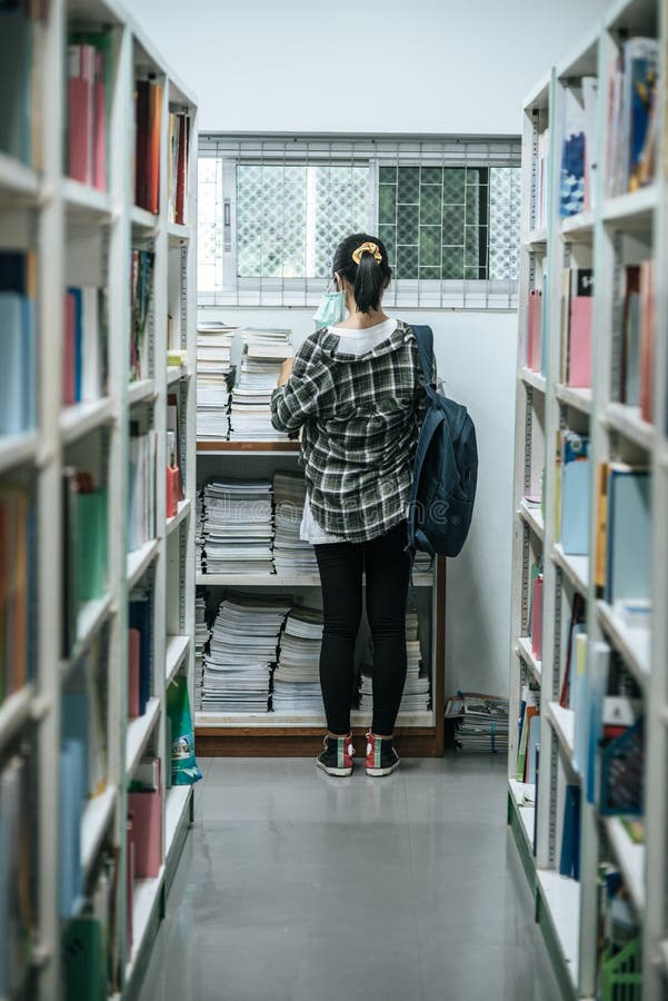 Women Carrying a Backpack and Searching for Books in the Library Stock ...