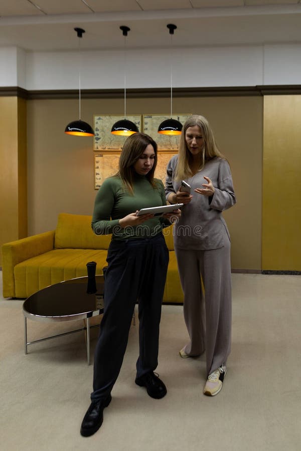 Women Collaborating in a Modern Workspace while Examining a ...