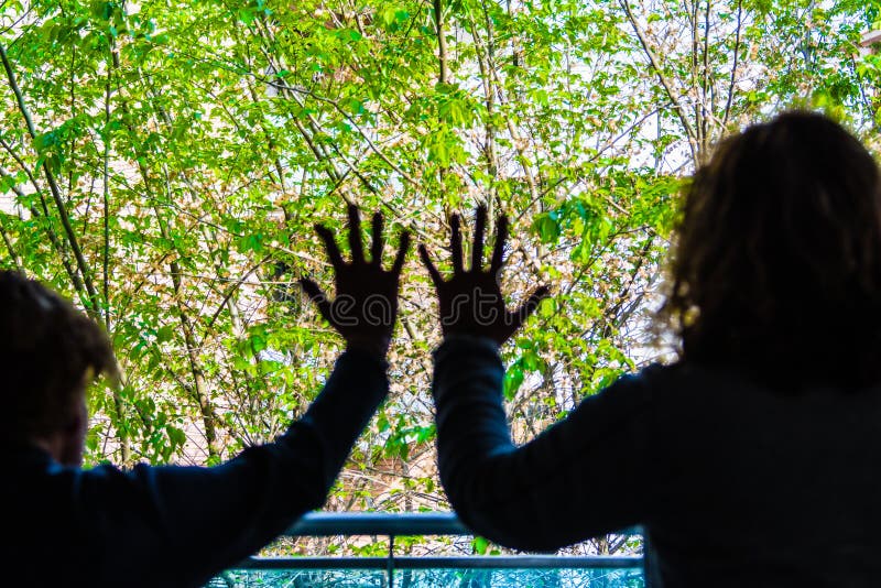 Women in Confinement with Hands on Window Pane Looking at Street Stock ...