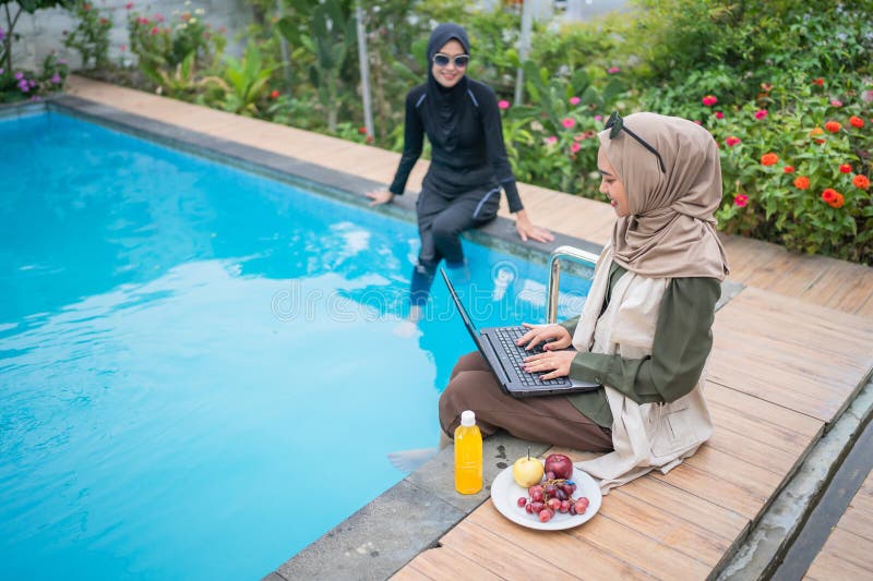 Women Engaged in Work by the Poolside while Enjoying Their Laptops and ...