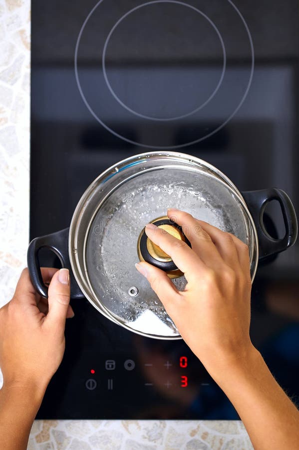 Women Hand Open a Saucepan in Modern Kitchen with Induction Stove Stock ...