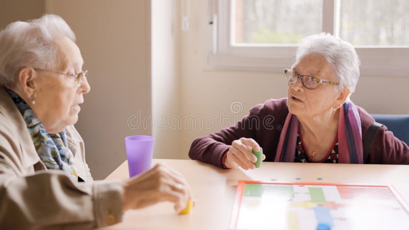 Women Having Fun Playing Parcheesi Board Game in a Geriatric Stock ...