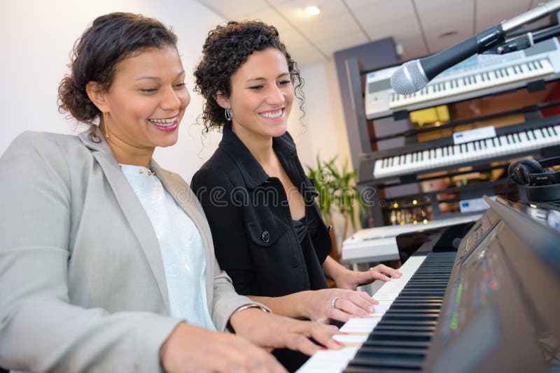 Women looking at piano stock photo. Image of portrait - 237933780