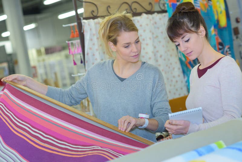 Women looking at textiles stock photo. Image of service - 122450088