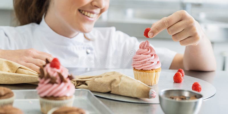 Women in Pastry Bakery Working on Muffins Putting a Raspberry on Top ...