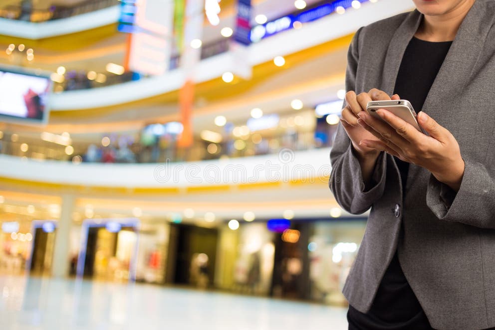 Women in Shopping Mall Using Mobile Phone. Stock Photo - Image of store ...