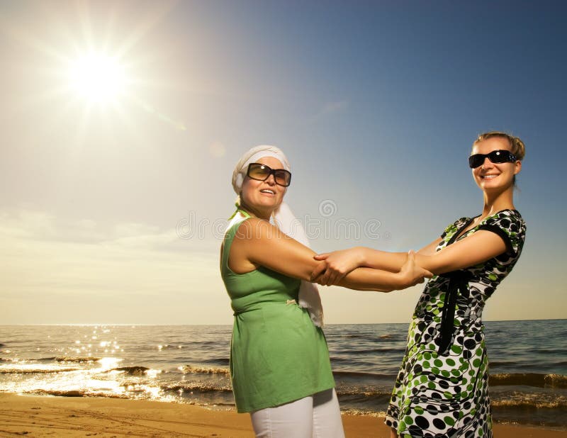 Women sitting on the beach stock photo. Image of seaside - 5530960