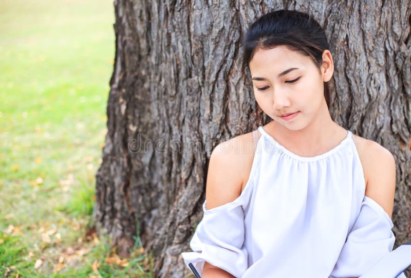 Women Sitting Near Big Tree and Drawing in the Park. Stock Photo ...