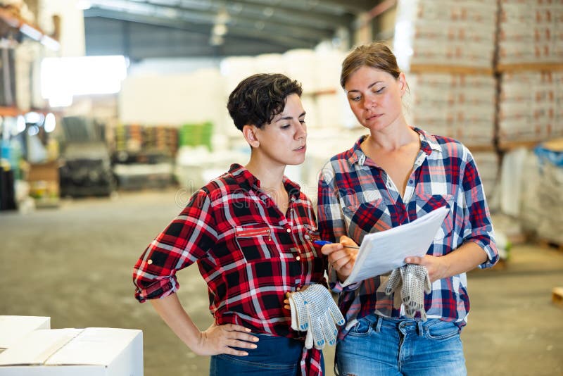 Women Standing in Warehouse and Talking about Documentation Stock Image ...