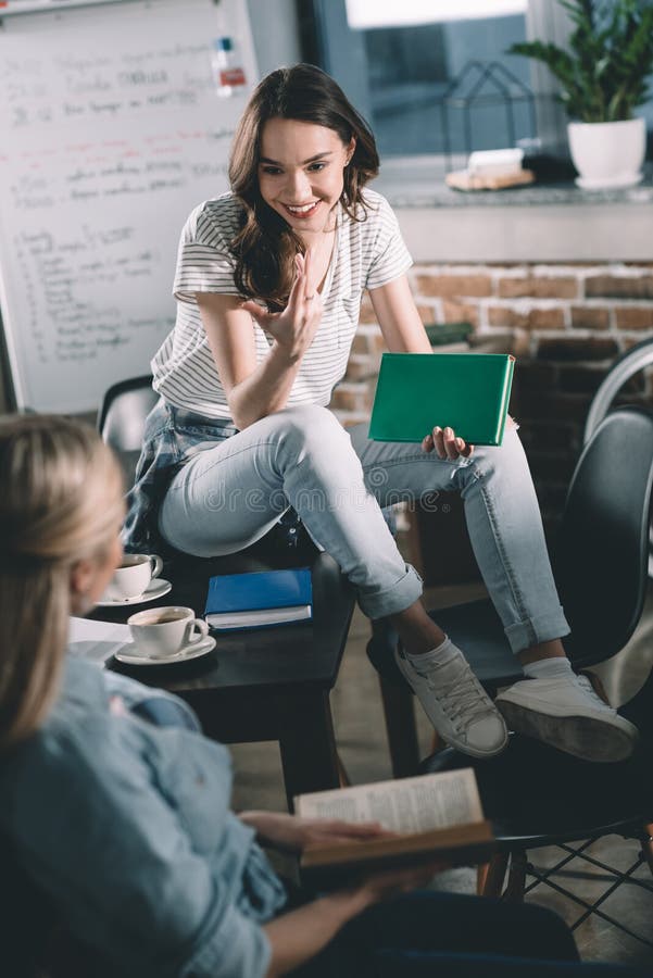 Women Students Having Conversation while Studying Together Stock Photo ...