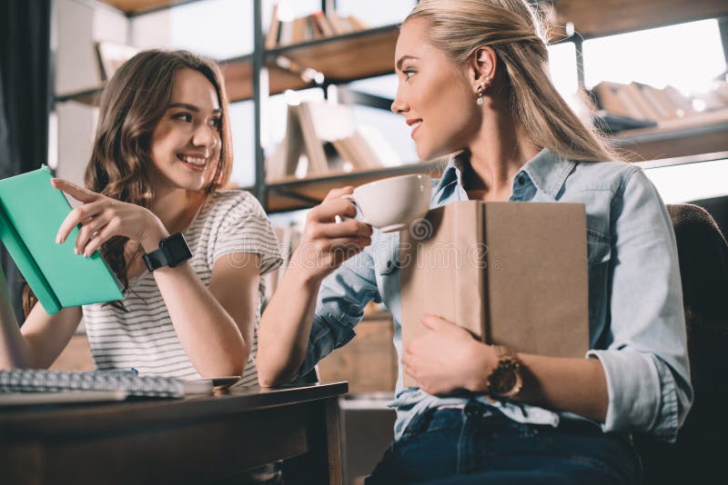 Women Students Having Conversation while Studying Together Stock Image ...