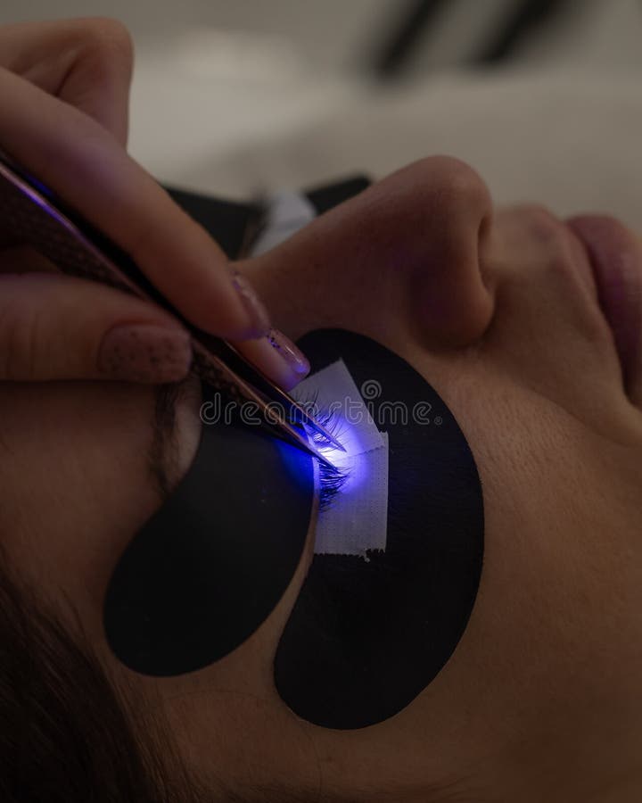 A Woman Undergoing Eyelash Extension Procedure Using an Ultraviolet ...