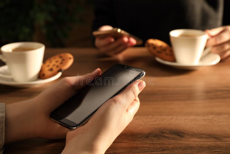 Women Using Mobile Phones at Table in Cafe, Closeup Stock Image - Image ...