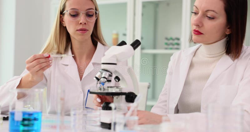 Women Work with Samples in Laboratory Using Microscope Stock Footage ...