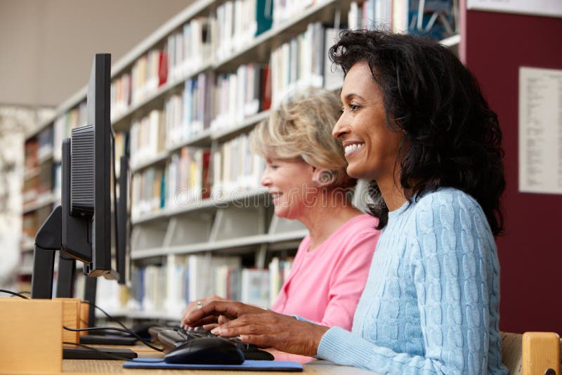 Women Working on Computers in Library Stock Photo - Image of forties ...