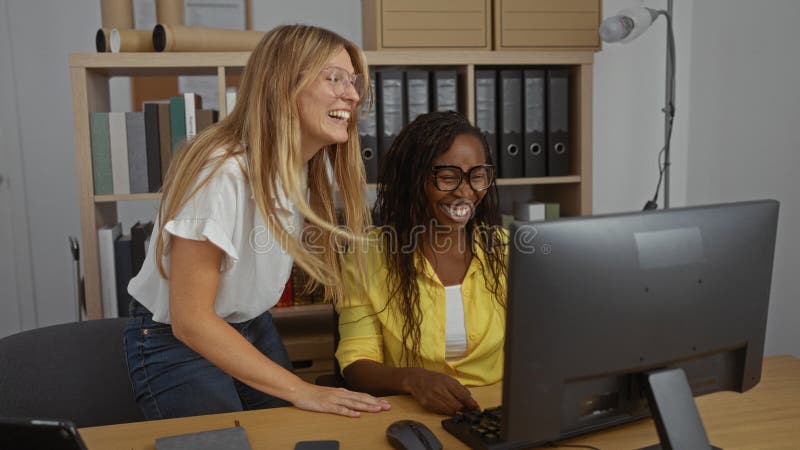 Women Working Together in an Office Setting, with One Pointing at the ...