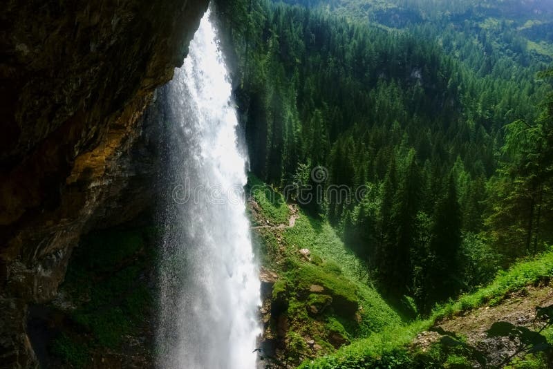 Wonderful High Waterfall Over a Cliff in the Mountains with a Forest ...