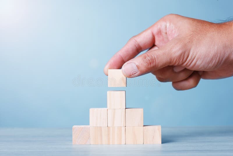 Wood Block Cubic Stack with Hand on Table Blue Tone Background. Stock ...
