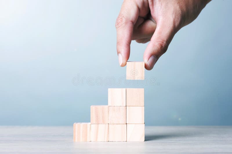 Wood Block Cubic Stack with Hand on Table Blue Tone Background. Stock ...