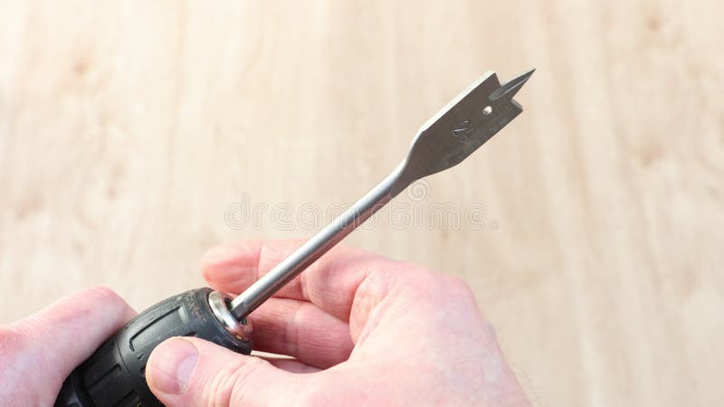 Hand Inserts Spade Bit into Chuck of Cordless Drill, Tightens Movable ...