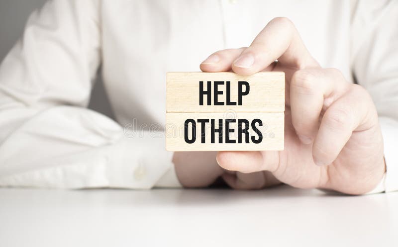 Wood Cube with Help Others Sign in Businessman Hands Stock Photo ...