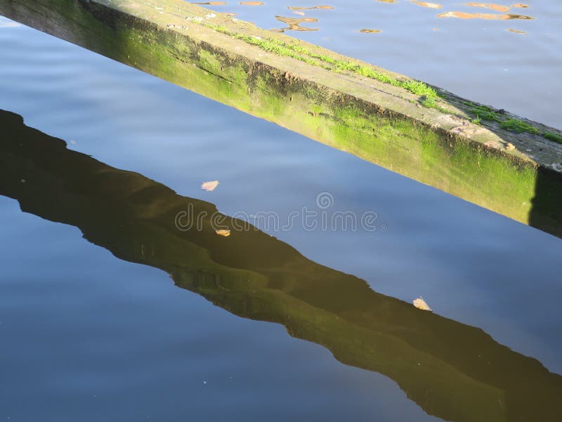 Wooden Bar or Beam Crossing the Water Makinga Shadow Stock Photo ...