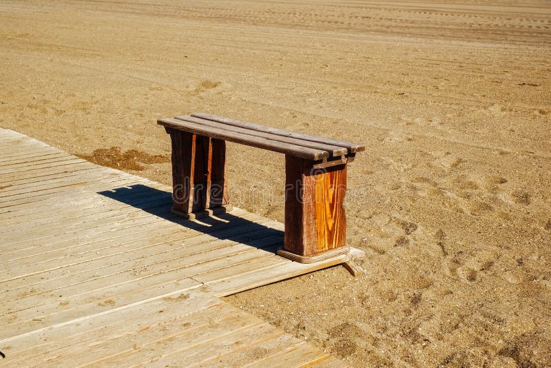 Wooden bench on the beach stock photo. Image of back - 111622578
