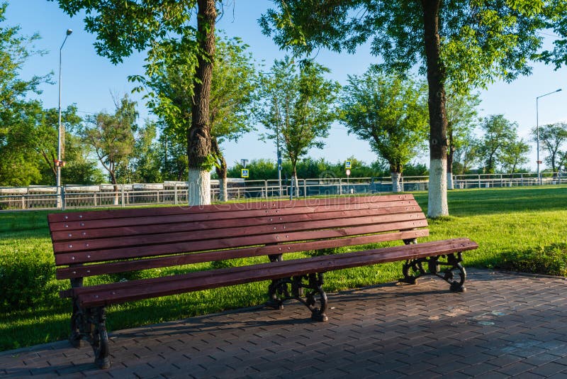 A Wooden Bench on a Path Paved with Decorative Stones in the Park in ...