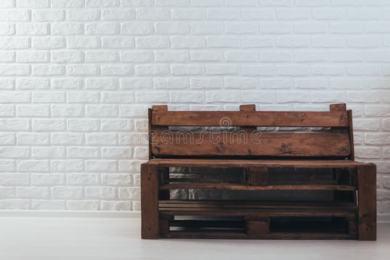 Wooden Bench of Flying Against a White Brick Wall Stock Image - Image ...