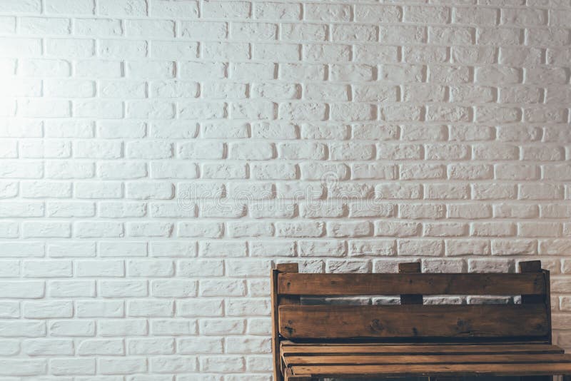 Wooden Bench of Flying Against a White Brick Wall Stock Photo - Image ...