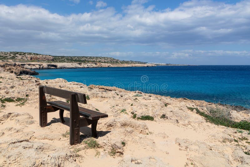 A Wooden Bench by the Ocean. Sea with Blue Water and a Rest Bench on ...