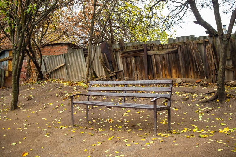 Wooden Bench in an Old Yard with an Old Wooden Fence and Trees Stock ...