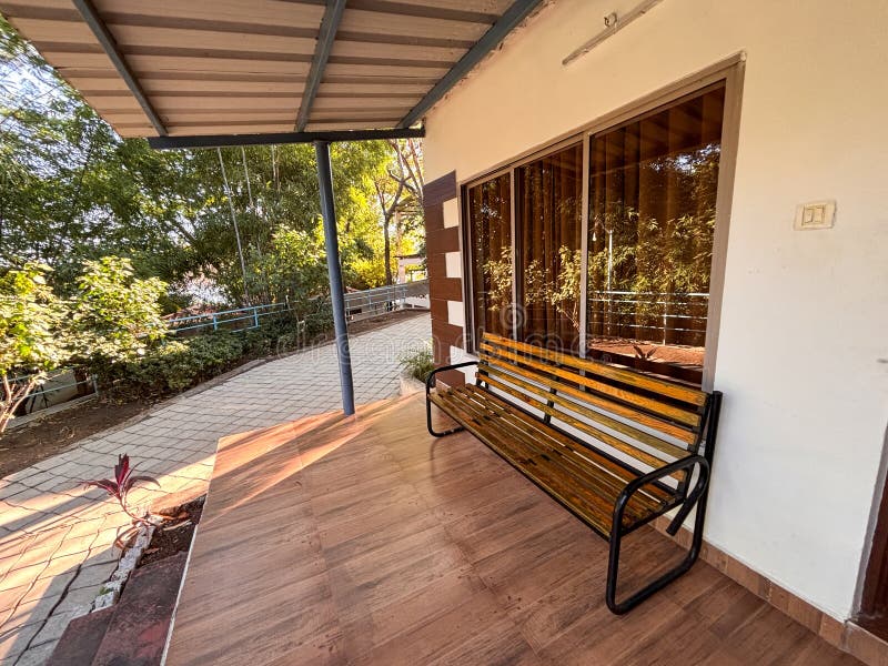 A Wooden Bench is Outside of a House with a View of Trees Stock Photo ...