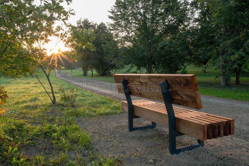 A Wooden Bench by the Path in the City Park Stock Photo - Image of ...