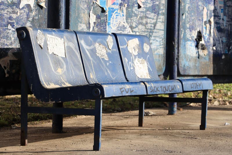 A Bench in Front of Blue Graffiti on a Wall with Writing Stock Image ...