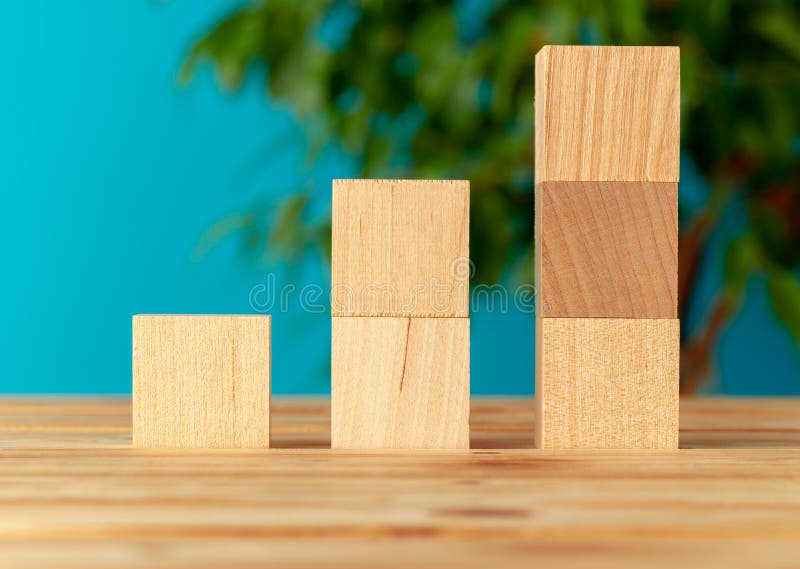 Wooden Blocks on Desk Against Blurred Plant Background Stock Photo ...