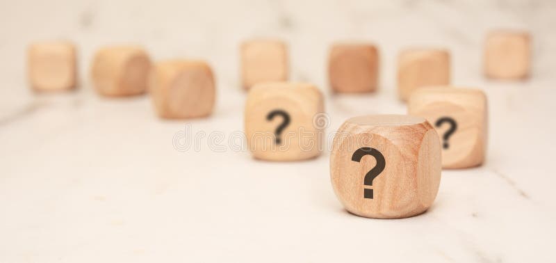 Wooden Blocks with Question Marks on a Marble Surface, Symbolizing ...