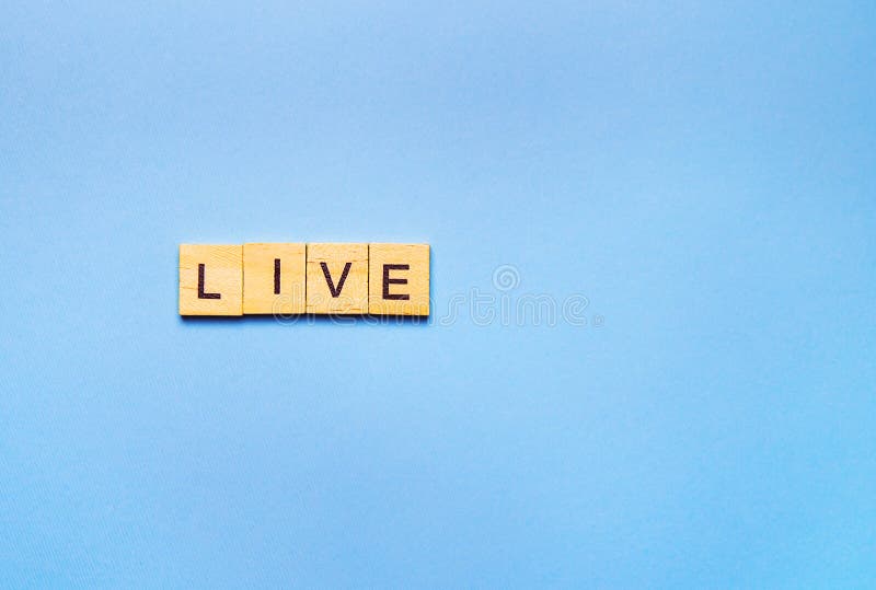 Wooden Blocks Spelling Out the Word LIVE on a Light Blue Background ...