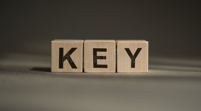 A Wooden Blocks with the Word KEY Written on it on a Gray Background ...
