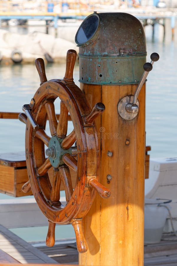 Wooden Boat Wheel with a Wooden Handle, Mounted on a Dock in an Outdoor ...