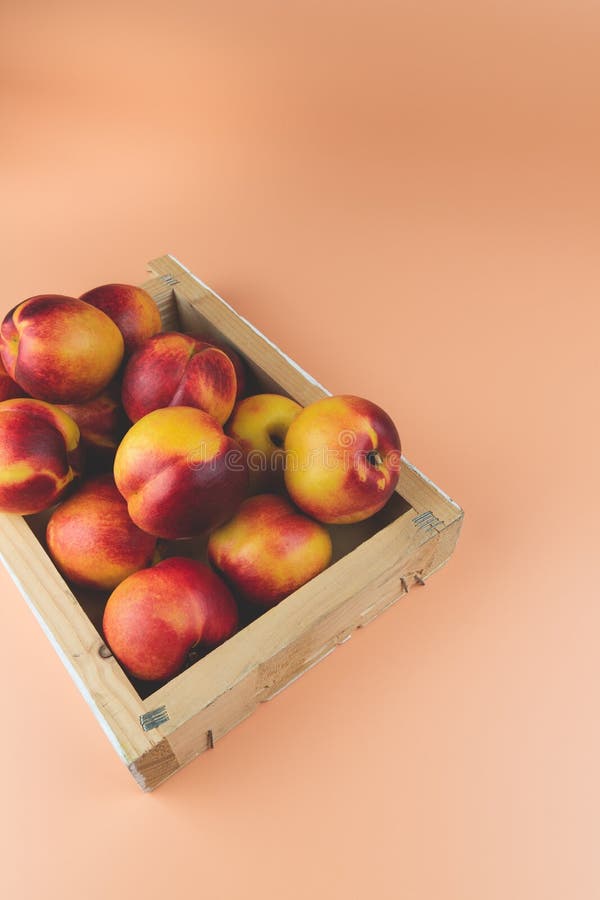 A Wooden Box Full of Nectarines, on a Peachy Color Background Stock ...