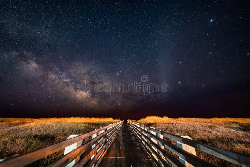 Wooden Bridge Illuminated by Moonlight and Starry Night Across a Meadow ...